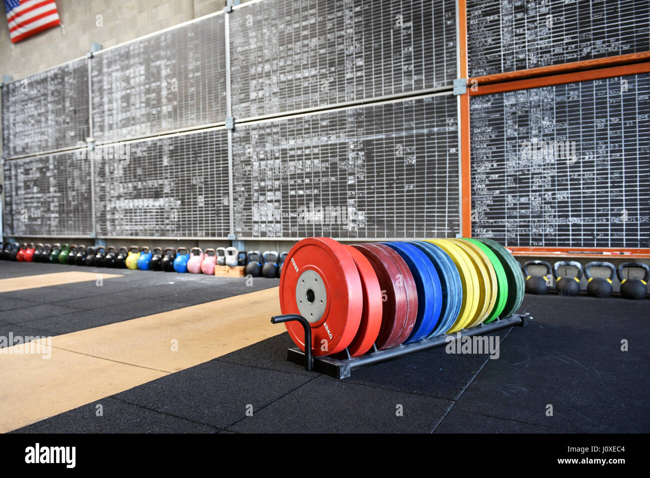 Rack of colorful training weights in a crossfit gym with a long row of ...