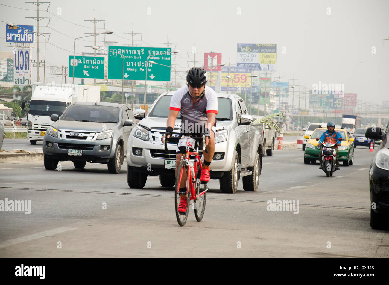 Asian thai people biking bicycle in race on street highway with traffic ...