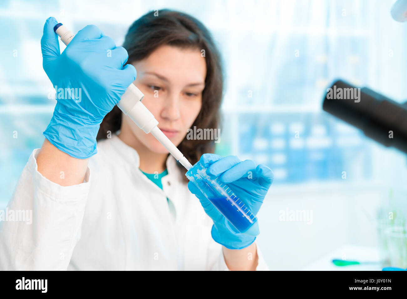 Woman technician with multipipette in genetic laboratory PCR research ...