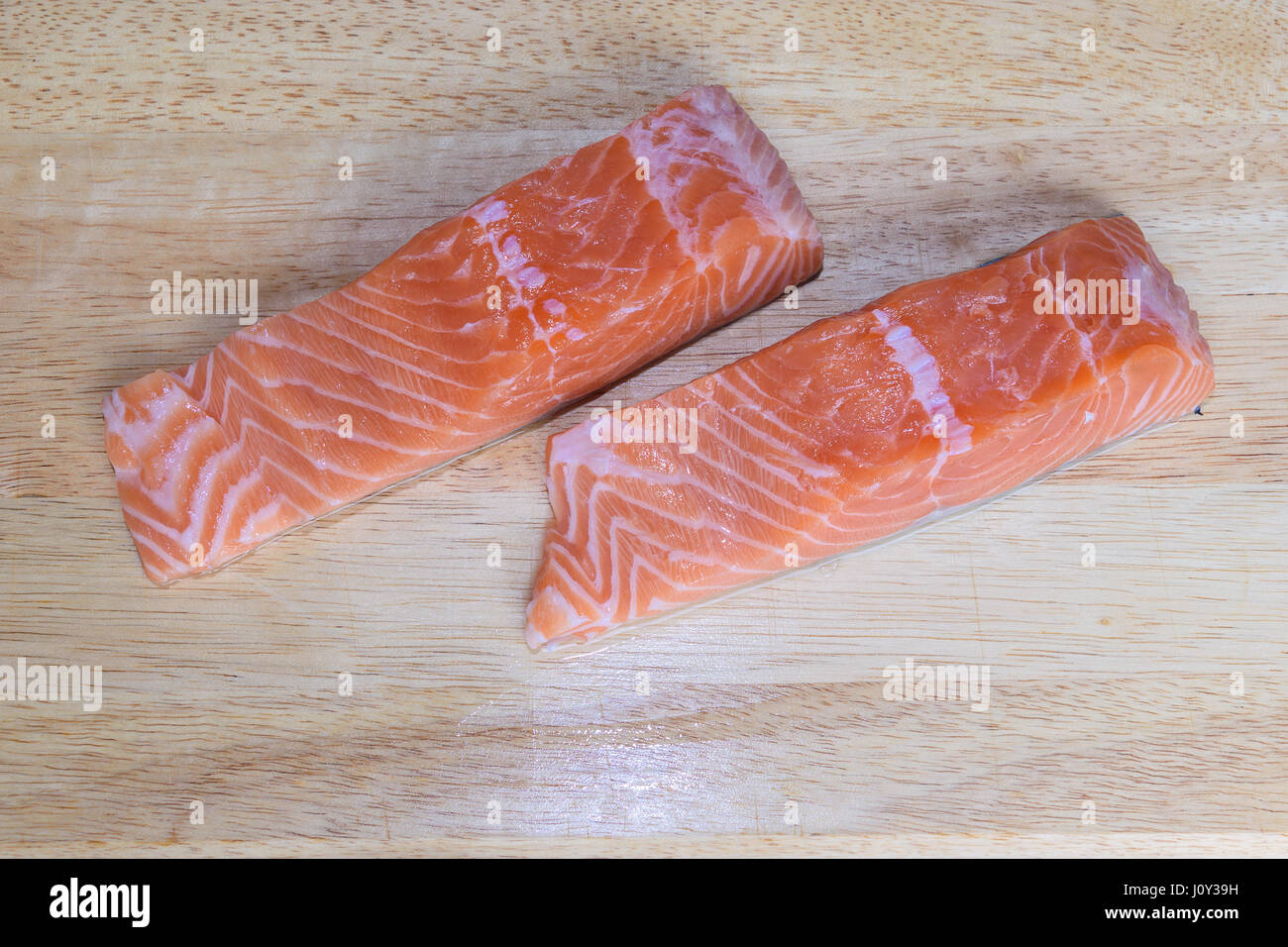 Two salmon portions on a wooden background Stock Photo - Alamy