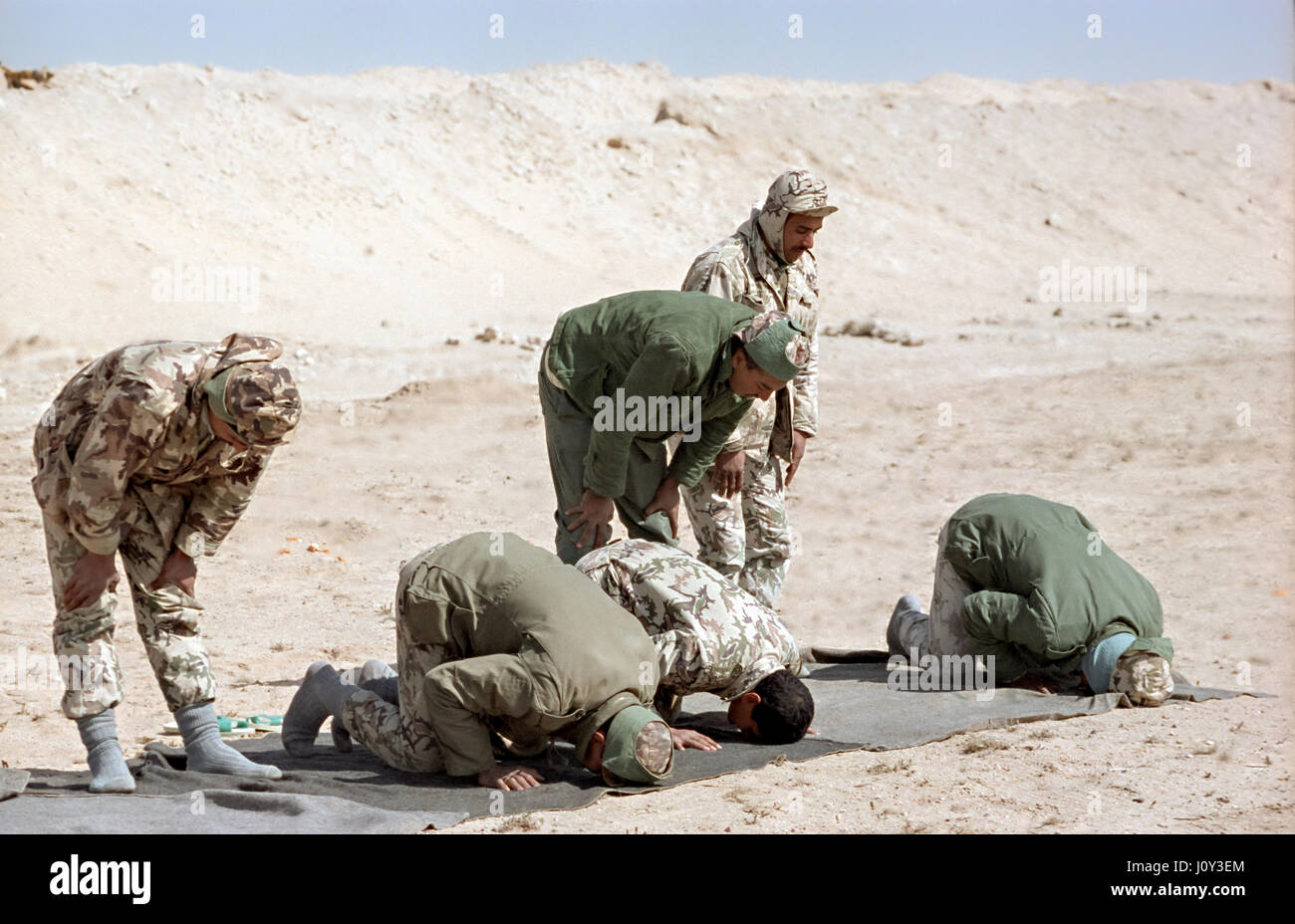 Egyptian soldiers perform afternoon prayers along the sand berm border ...