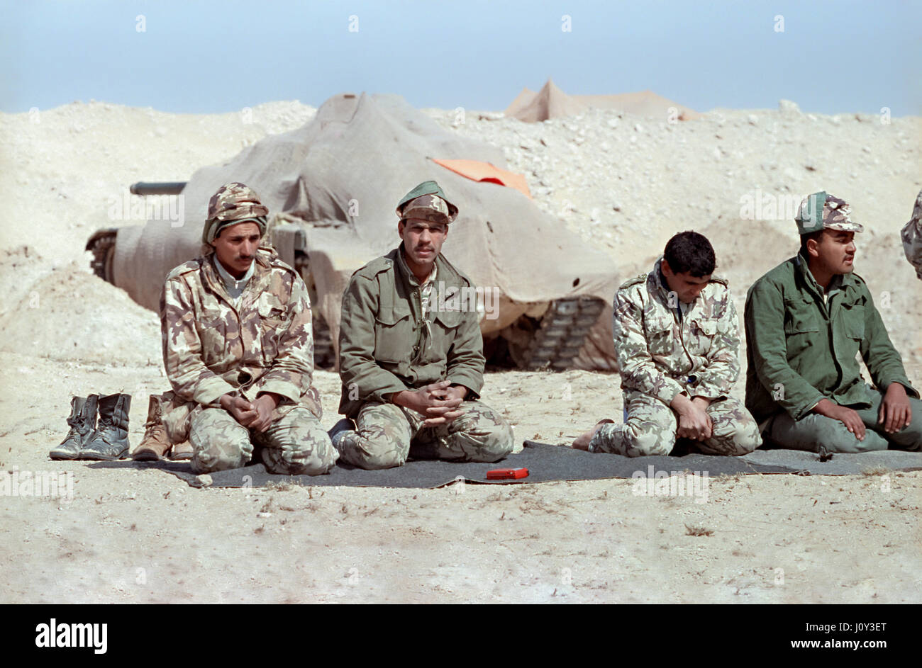 Egyptian soldiers perform afternoon prayers along the sand berm border ...
