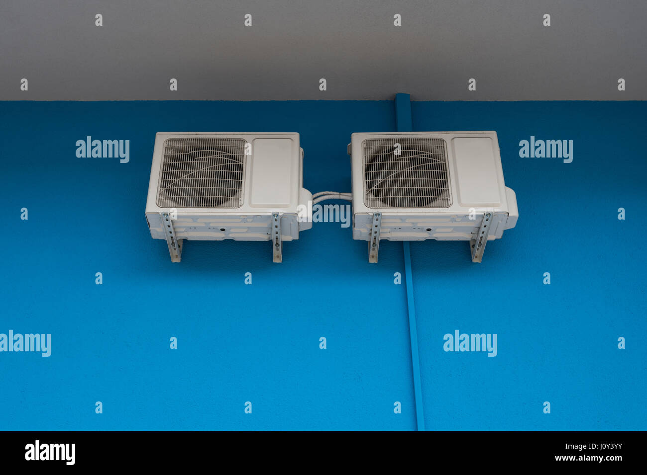 Air conditioner condensing units on blue wall outside the building ...