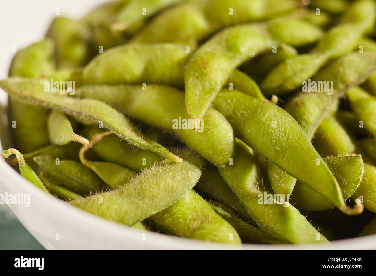 a bowl of cooked soybean pods called "edamame," ready to eat Stock ...