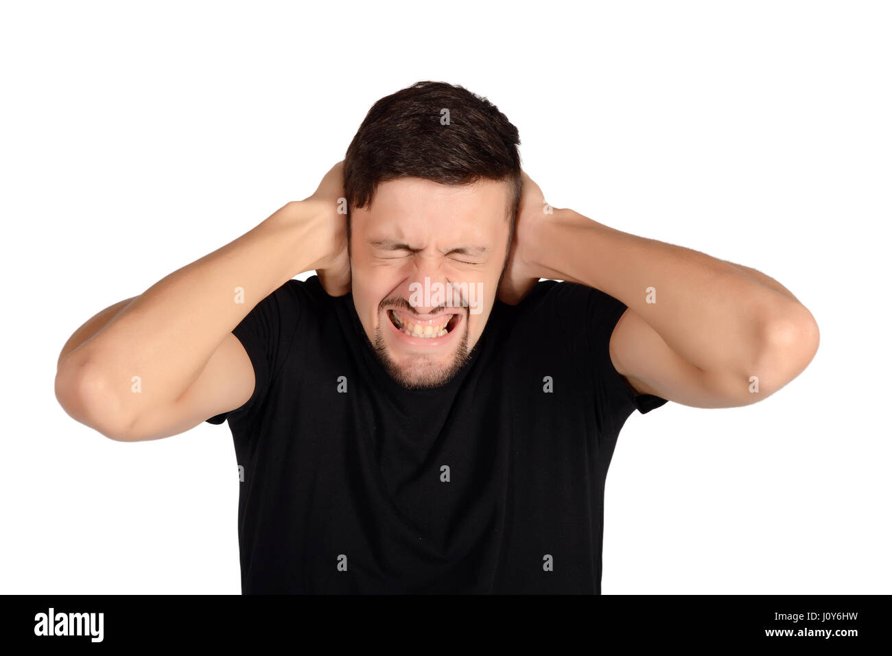Portrait of a young man covering his ears. Isolated white background ...