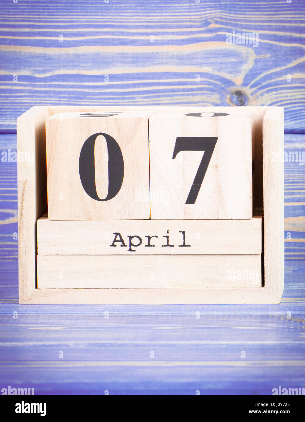 April 7th. Date of 7 April on wooden cube calendar, purple board as ...