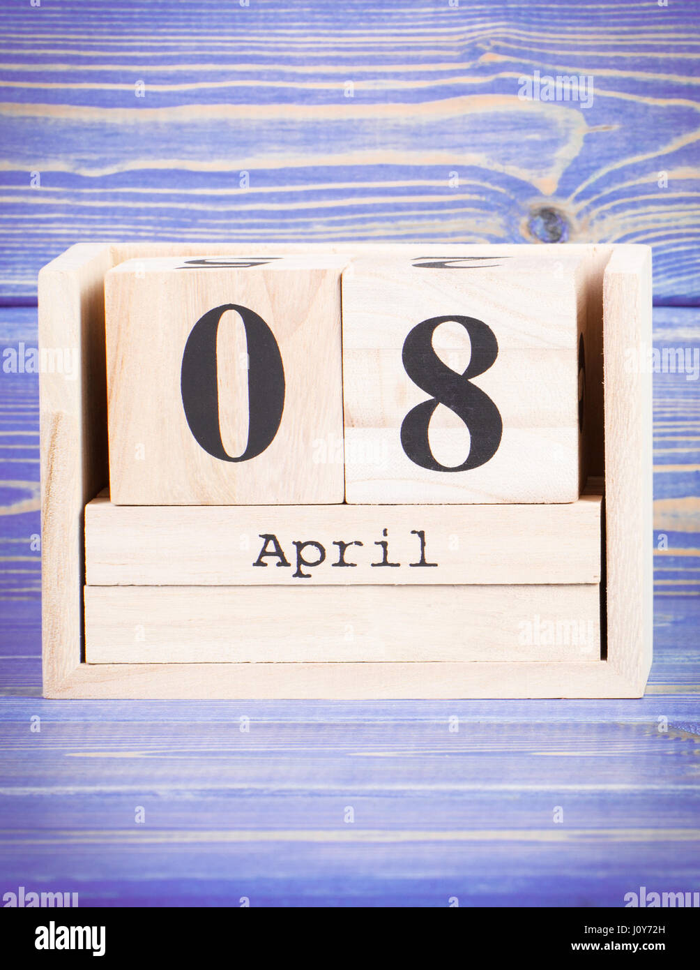 April 8th. Date of 8 April on wooden cube calendar, purple board as ...