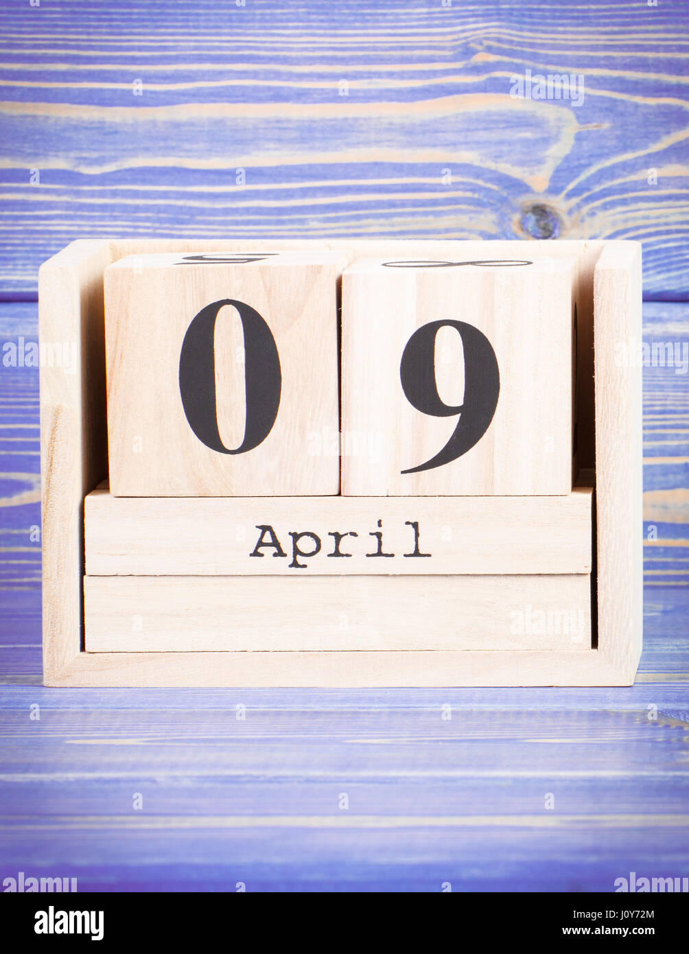 April 9th. Date of 9 April on wooden cube calendar, purple board as ...
