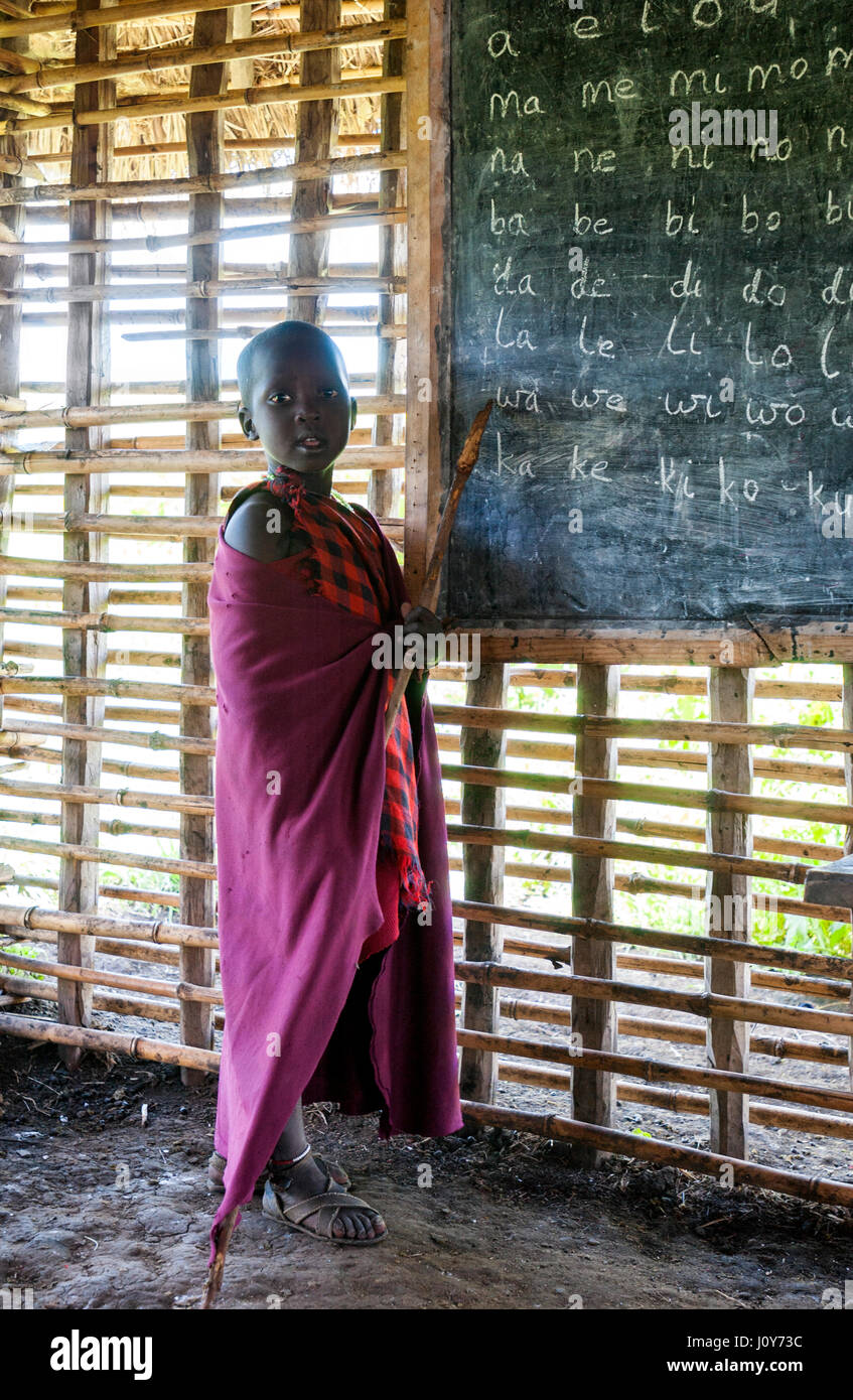 Maasai young schoolboy smiling in front of the blackboard at the ...