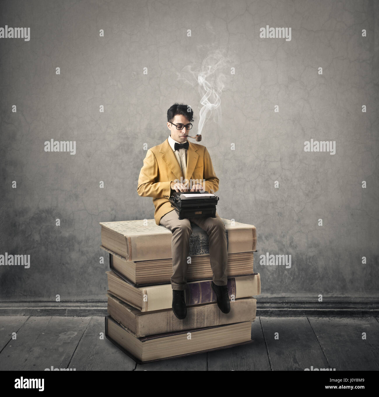 Writer man with typewriter sitting on books Stock Photo - Alamy