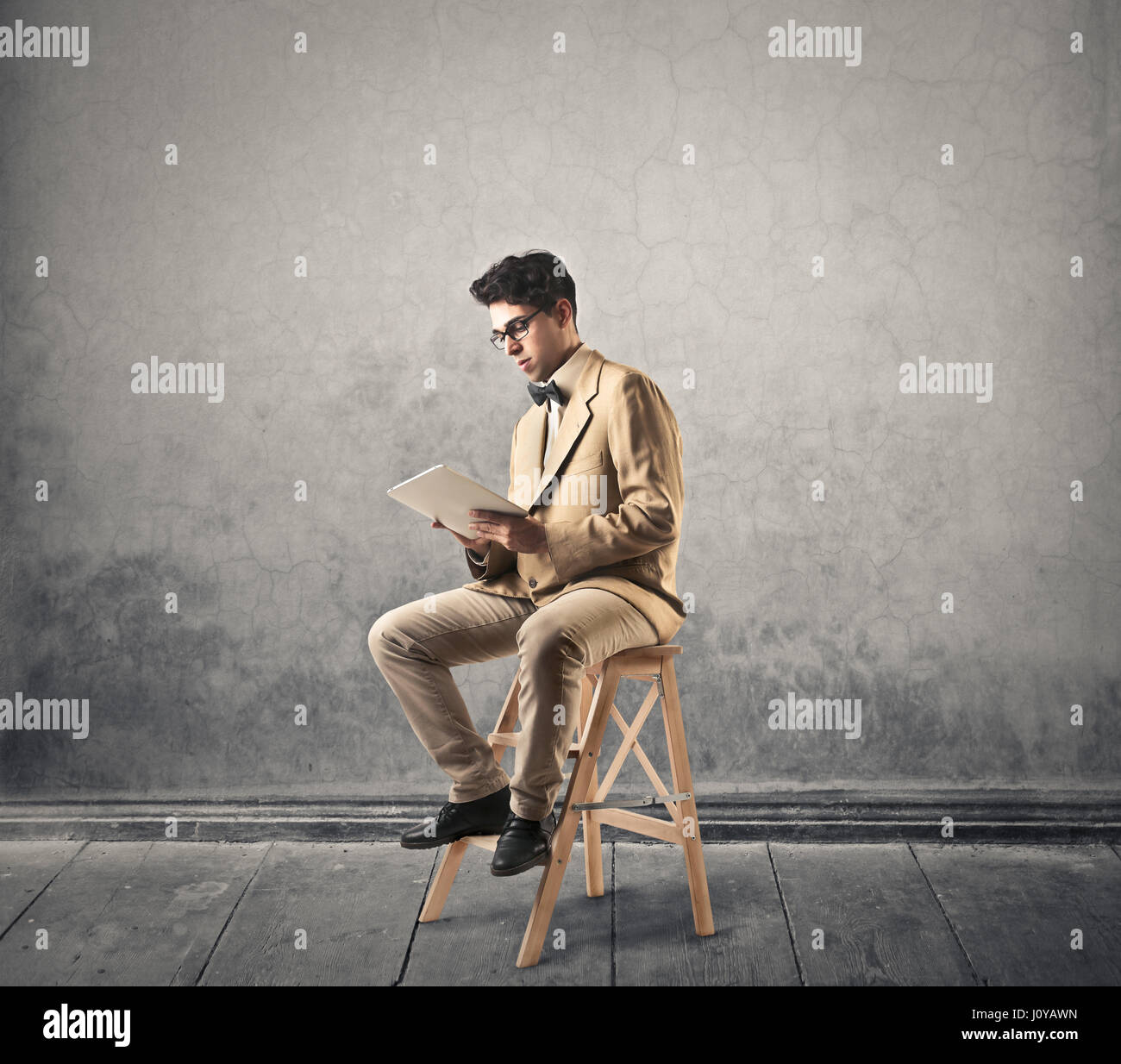 Businessman reading alone in empty room Stock Photo - Alamy