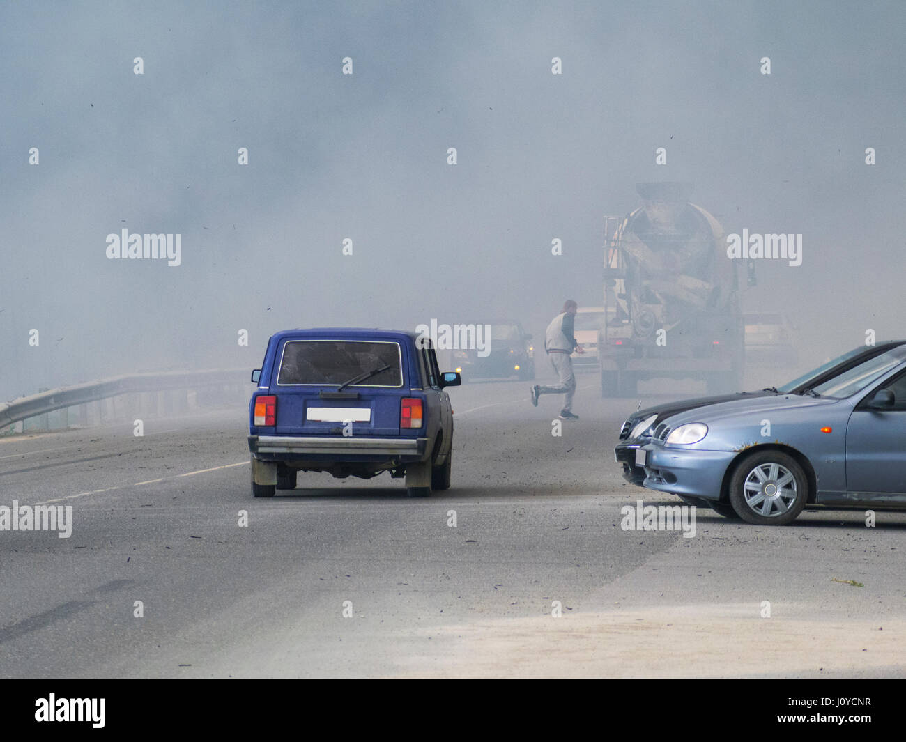 The smoky road, running man and cars Stock Photo - Alamy