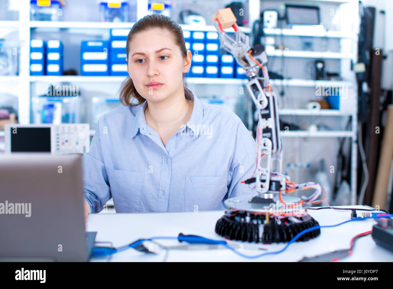 Girl in robotics laboratory. Young woman technician repair roboter ...