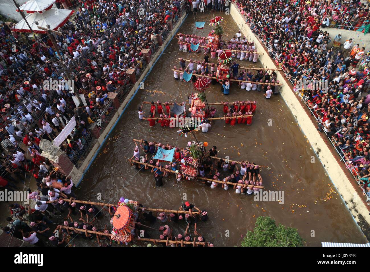 People carry chariots inside the pond in celebration of Tokha Bisket ...