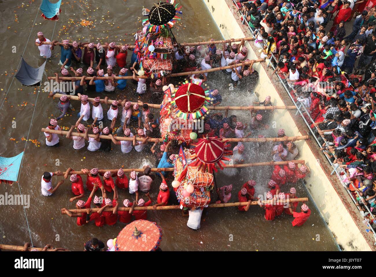 People carry chariots inside the pond in celebration of Tokha Bisket ...