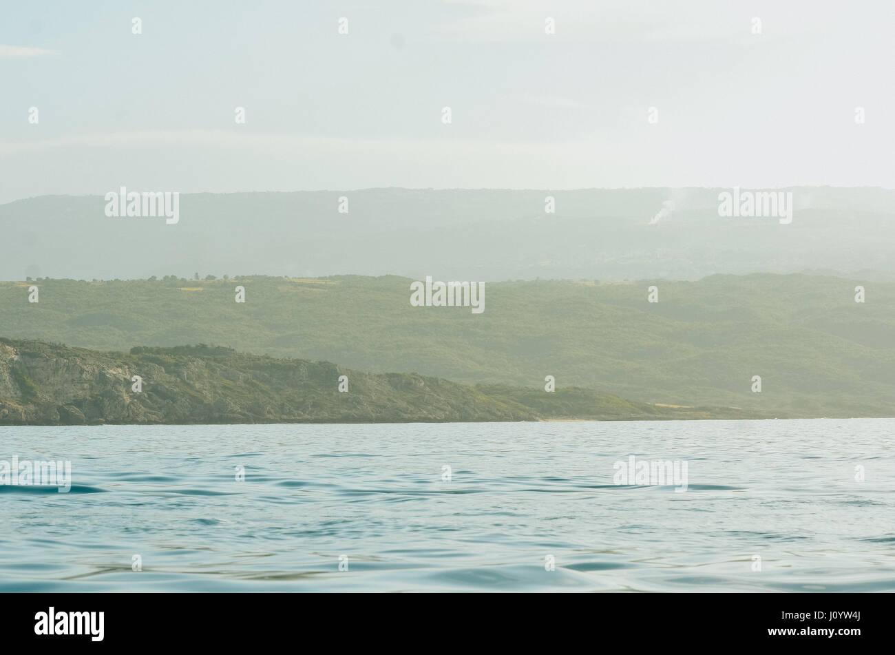 Water in the foreground. There are different layers of mountains in the ...