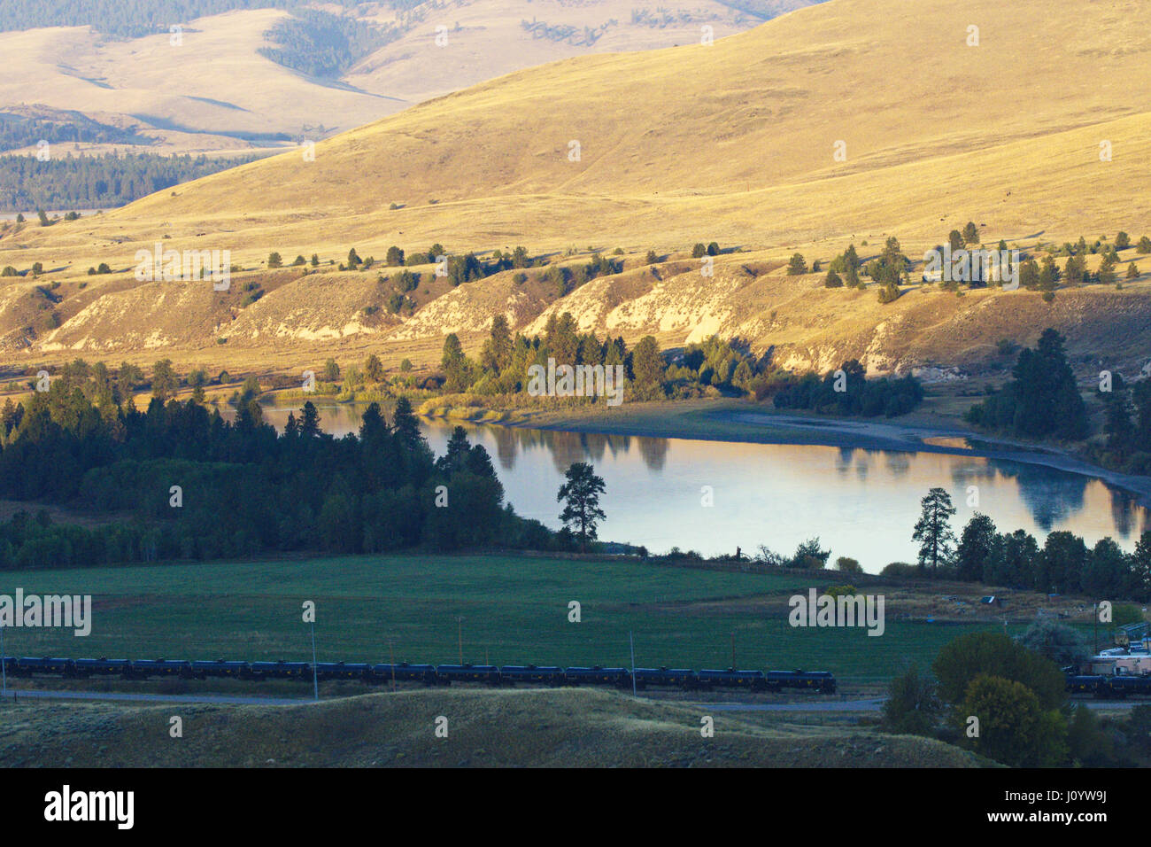 View of mountains, trees, lake, and moving train from National Bison ...