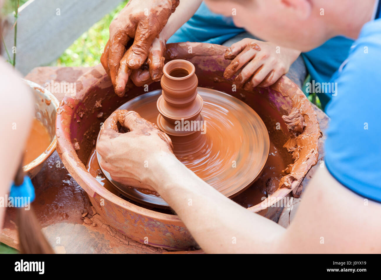 Teacher helps his student to work with red clay. Work on the potter's ...