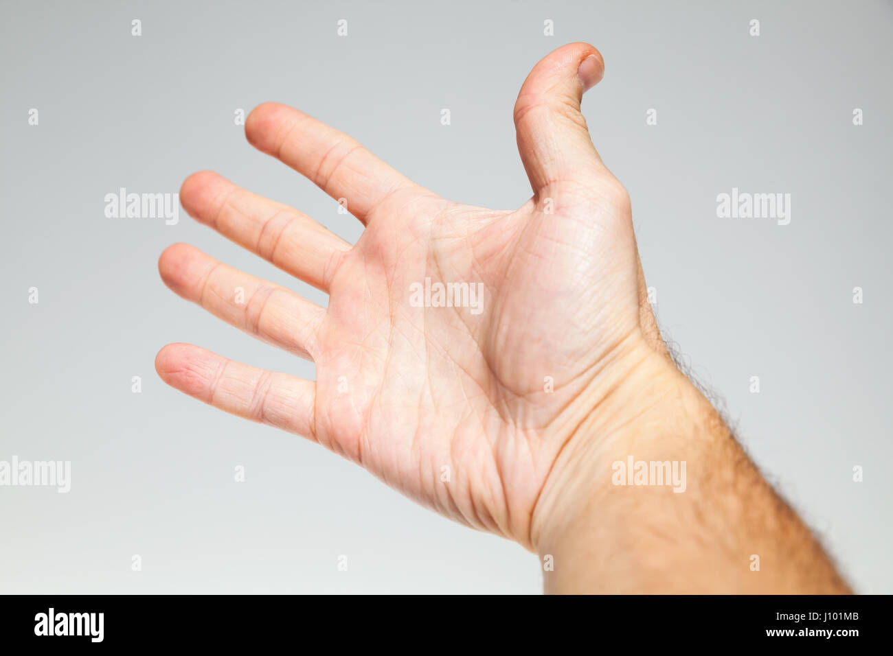 Male hand over gray wall background, close-up photo with selective ...