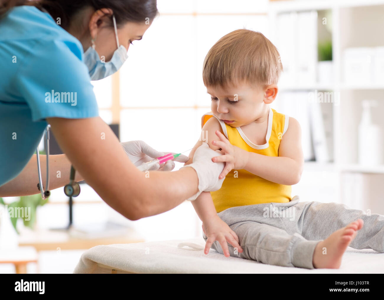 Doctor pediatrician give injection to boy's arm Stock Photo - Alamy
