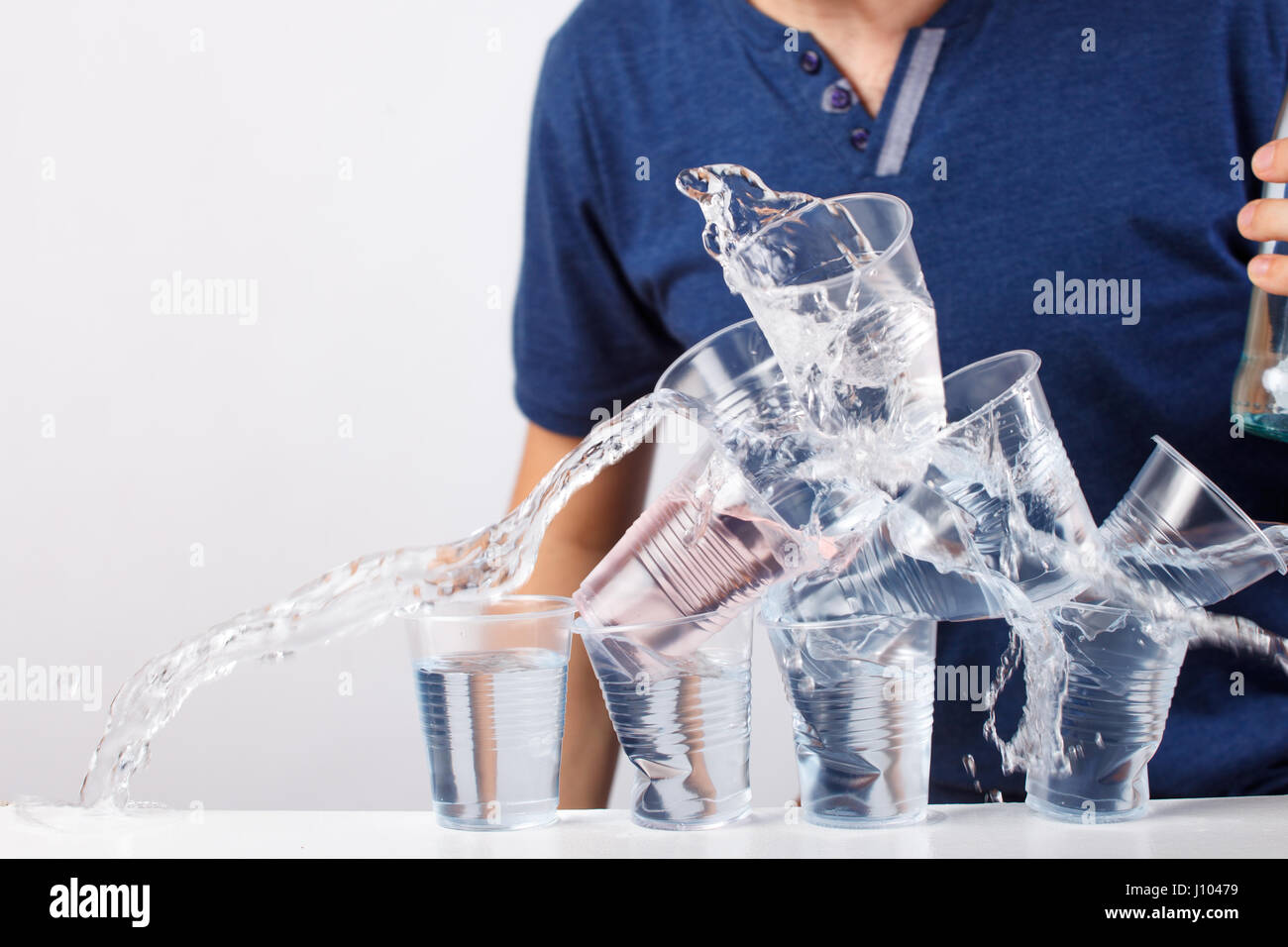 Overflowing fresh water into a plastic glass Stock Photo - Alamy