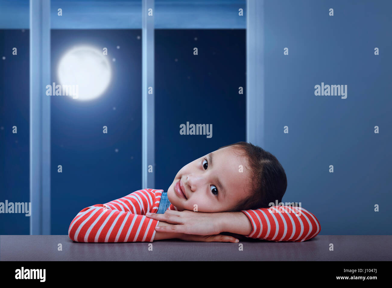 Portrait of asian child lying down on the table at night Stock Photo ...