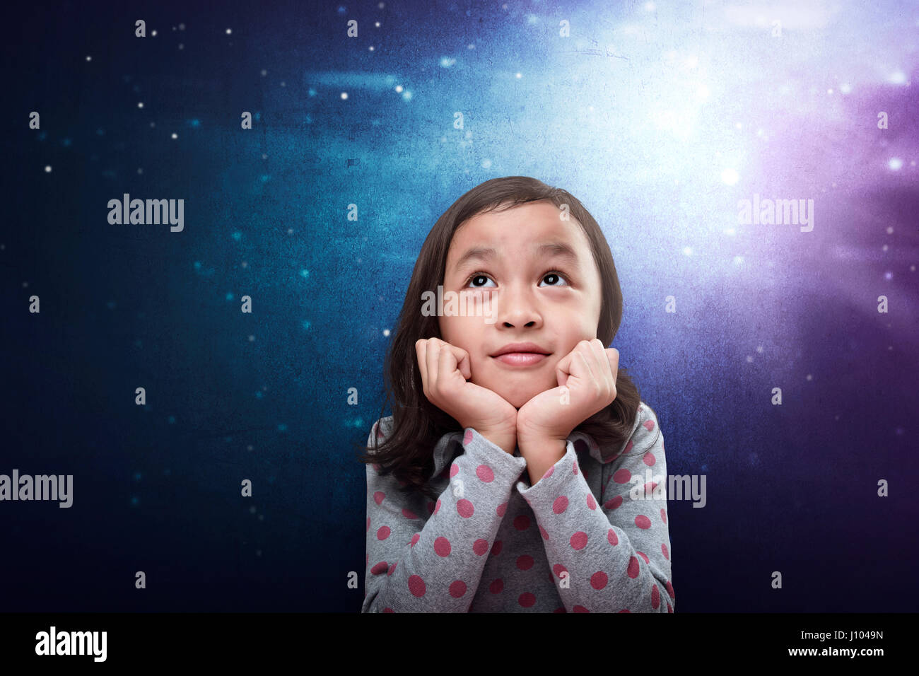 Cheerful asian kid thinking about something over futuristic background ...
