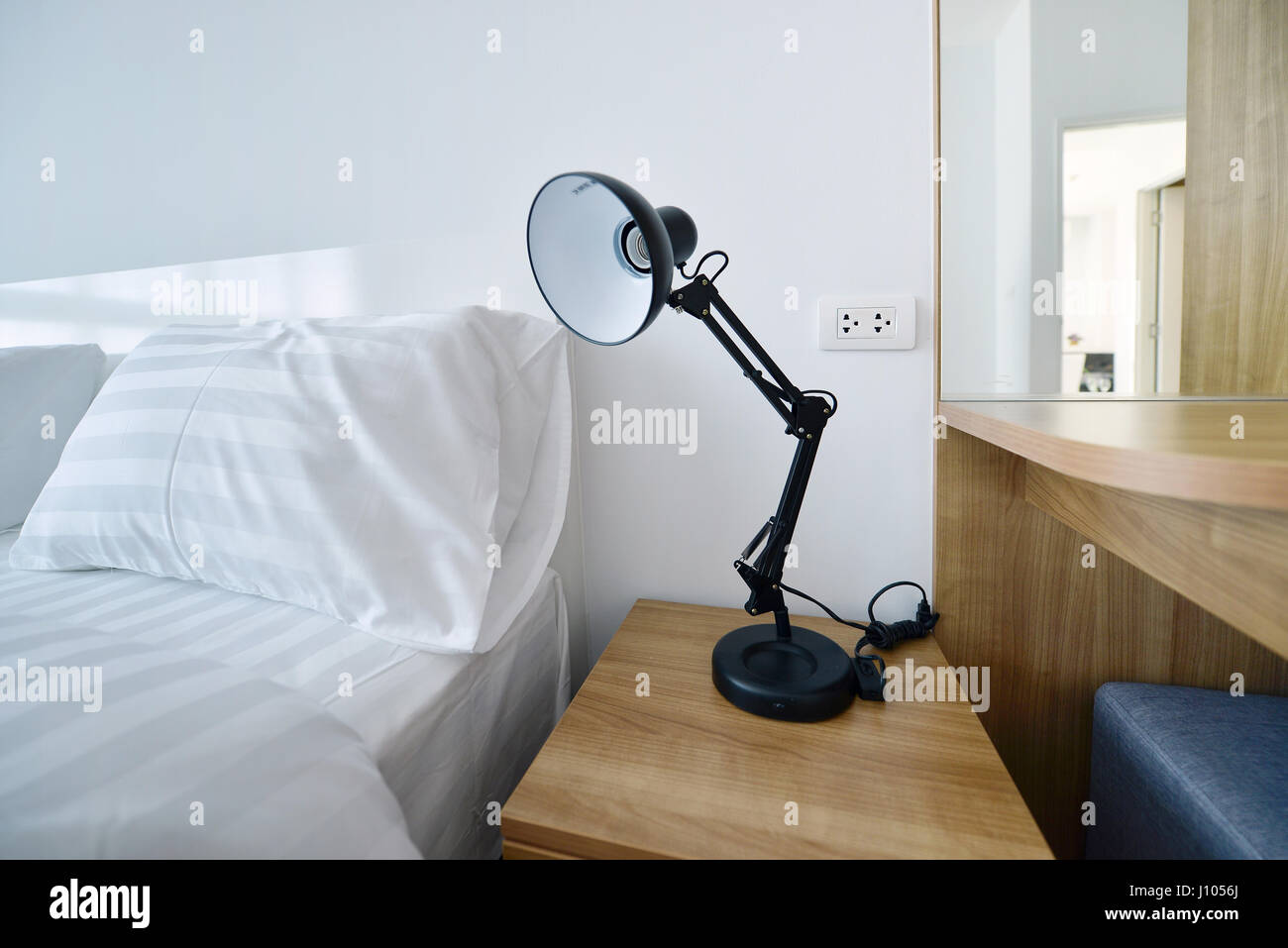 modern lamp on wooden nightstand in white modern bedroom, interior ...