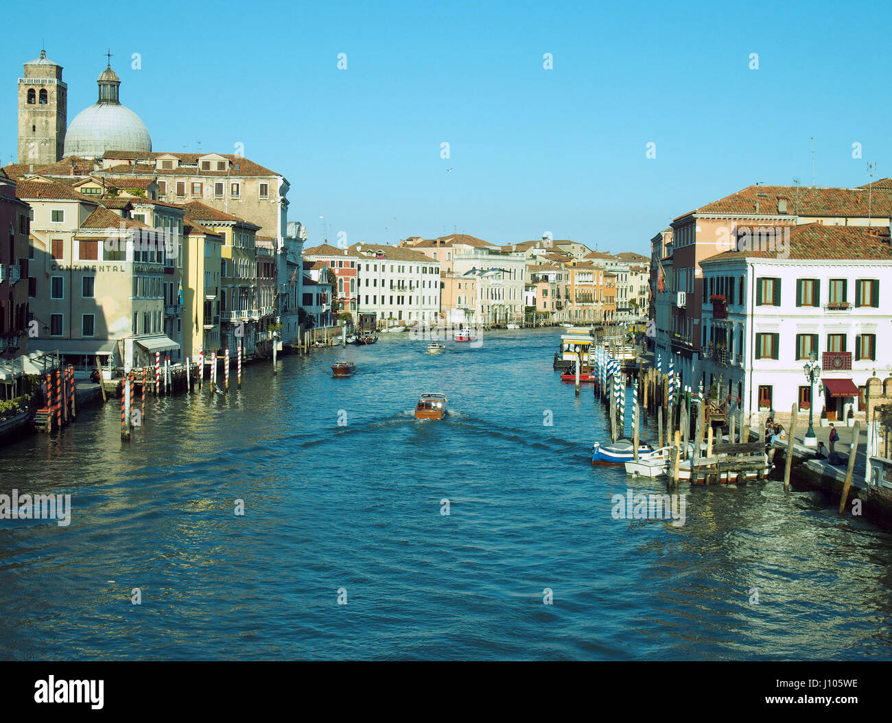 The grand canal in venice on a bright sunny day with a small boat ...