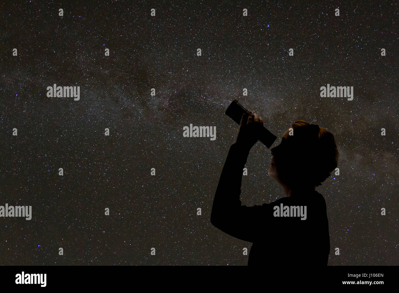 Woman looking through telescope at night sky Stock Photo - Alamy