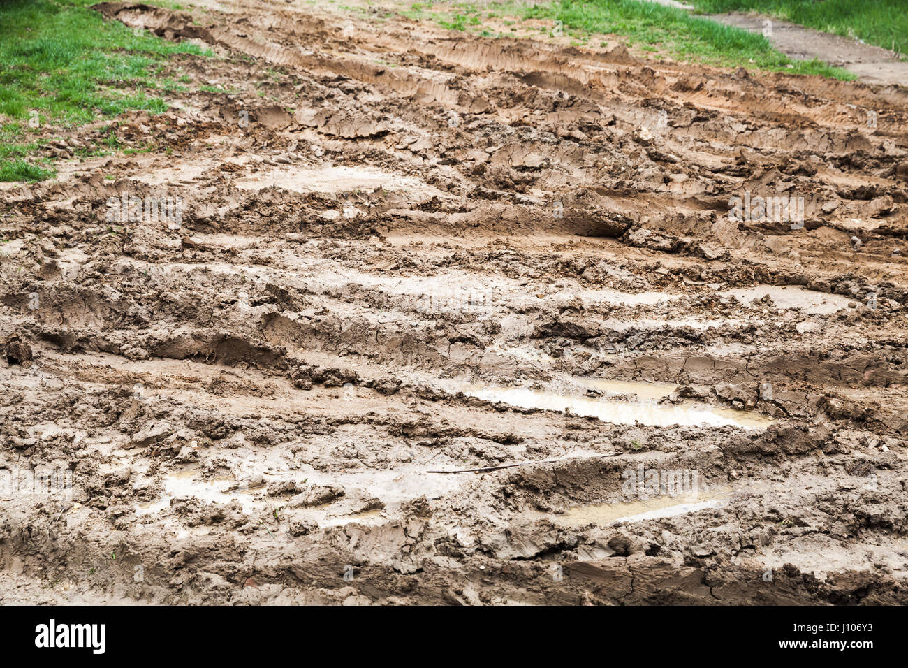 Dirty rural road with puddles and mud, countryside travel background ...