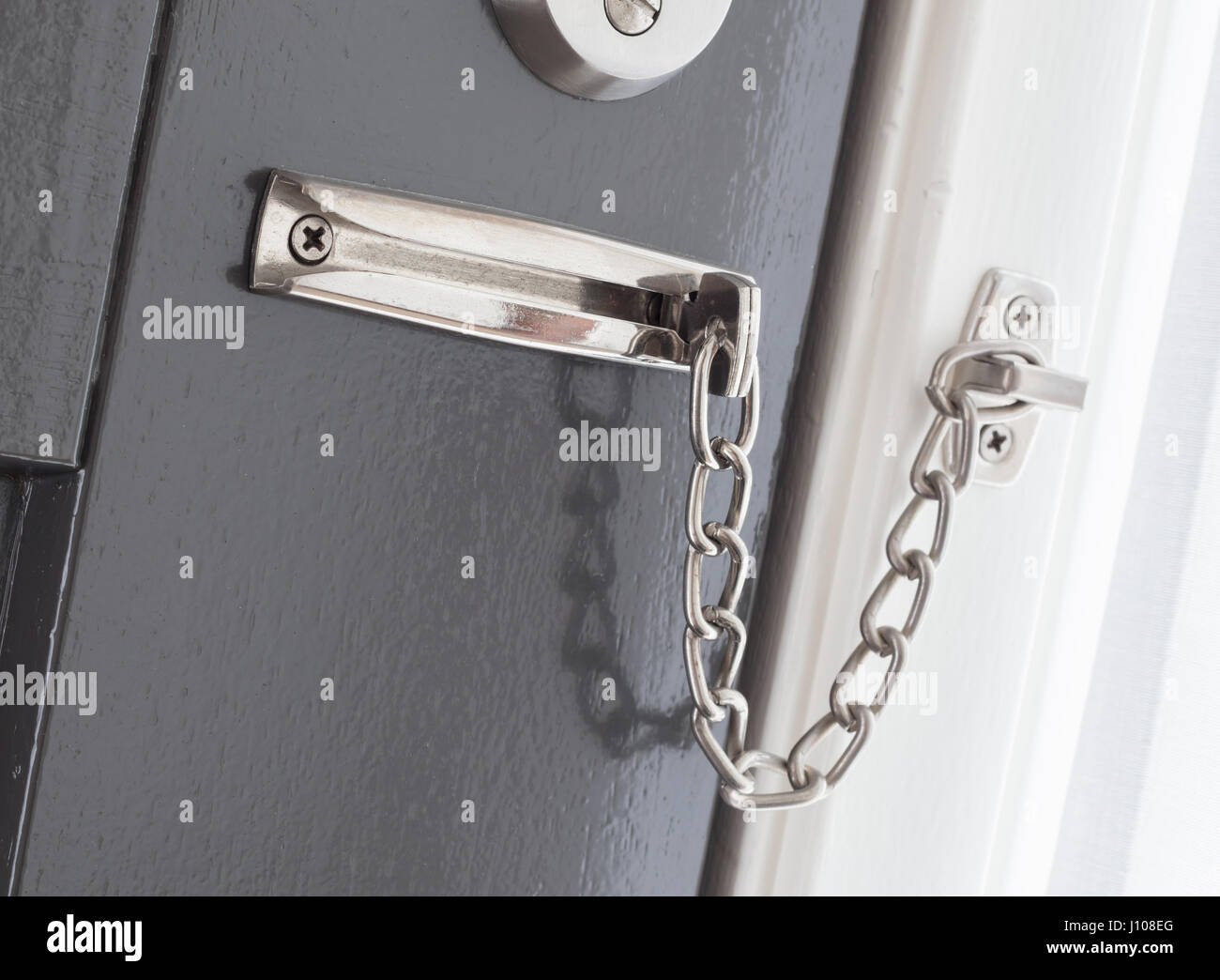Door chain on a grey door, security measures Stock Photo - Alamy