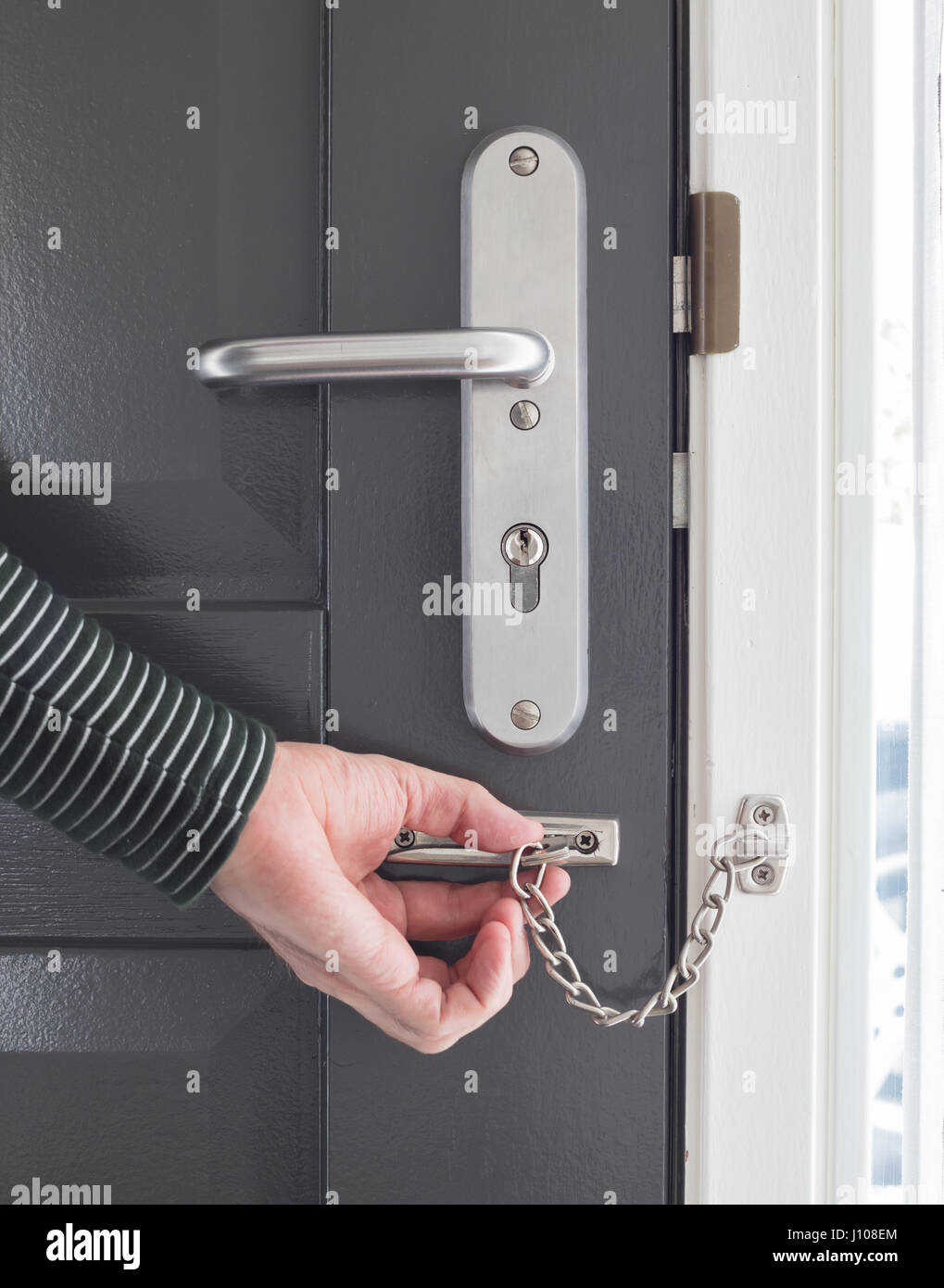 Door chain on a grey door, security measures Stock Photo - Alamy