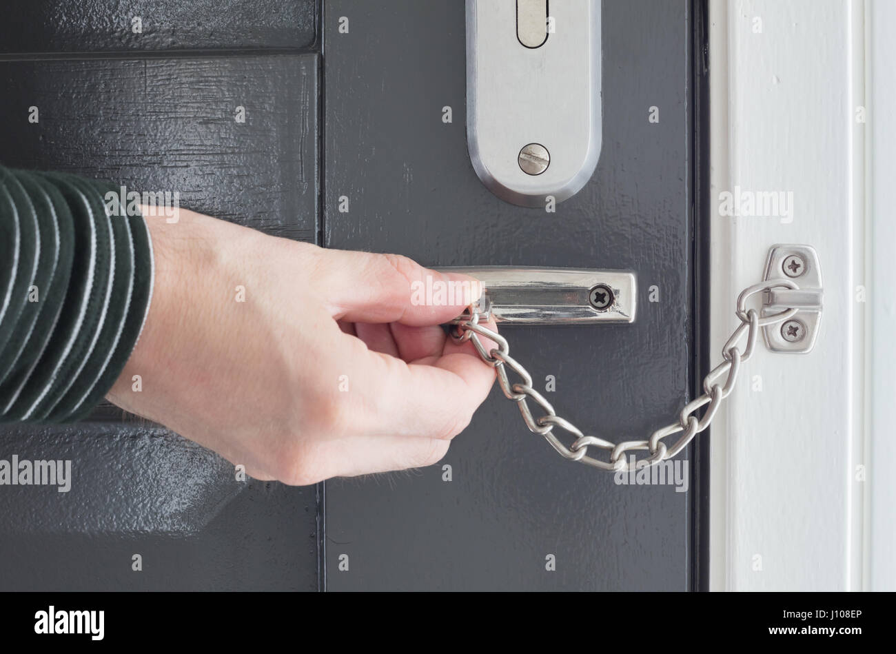 Door chain on a grey door, security measures Stock Photo - Alamy