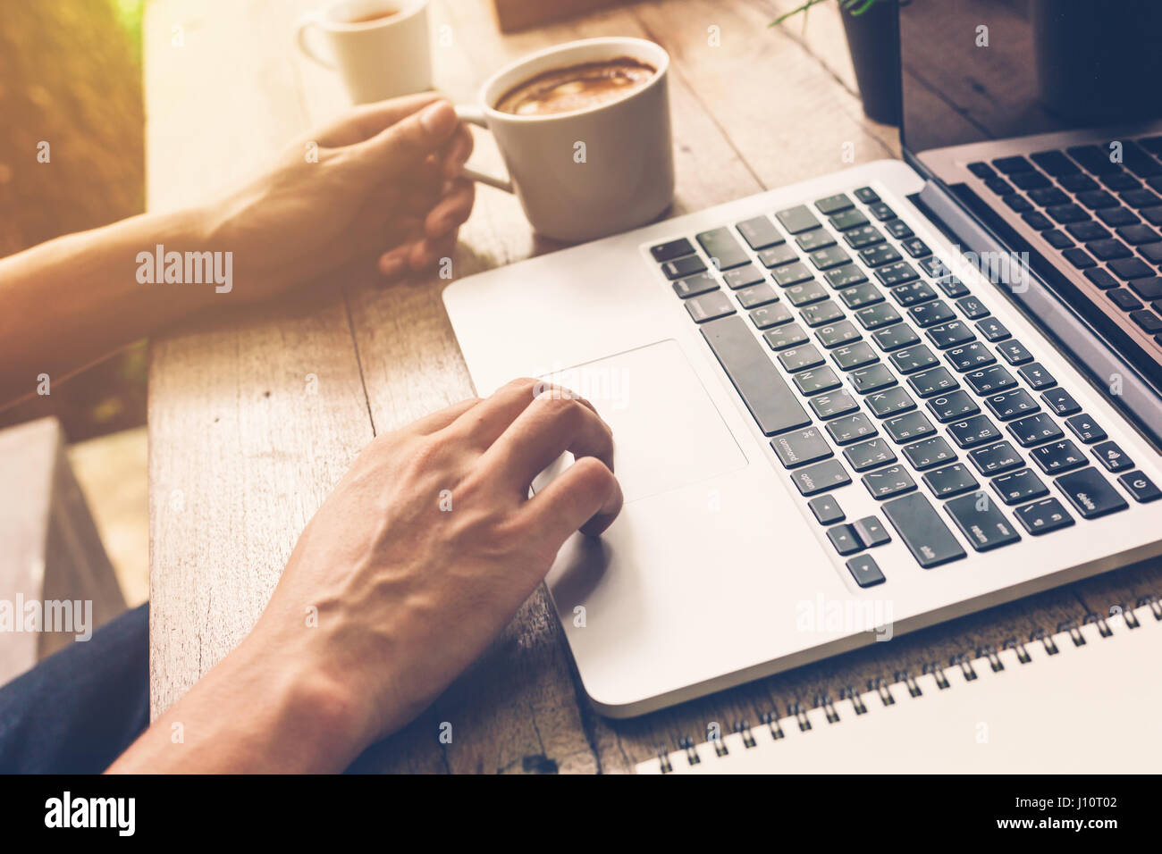 Hands of business man typing on a laptop and holding coffee in coffee ...