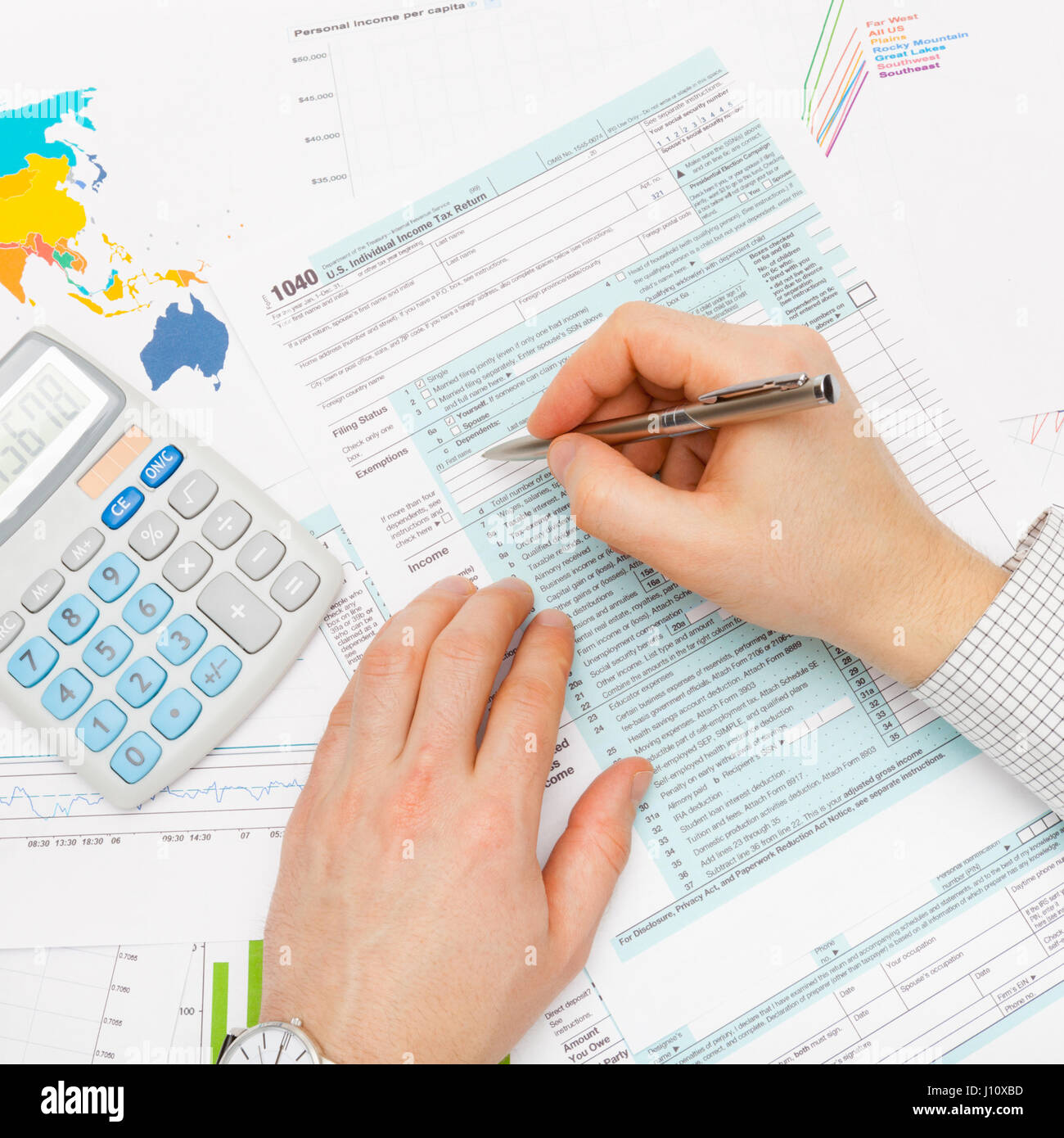 Male ready to fill out 1040 US Tax Form with calculator next to his ...