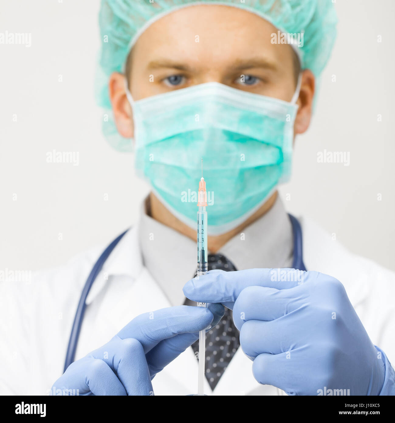 Doctor holding syringe with two hands and getting ready to make ...
