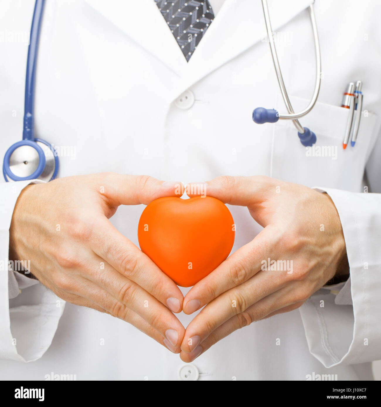 Doctor holding toy heart with two hands - medicine and healthcare ...