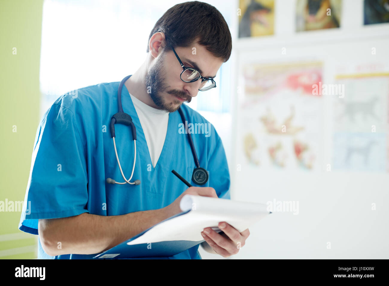 Young doctor making notes in clinic Stock Photo - Alamy