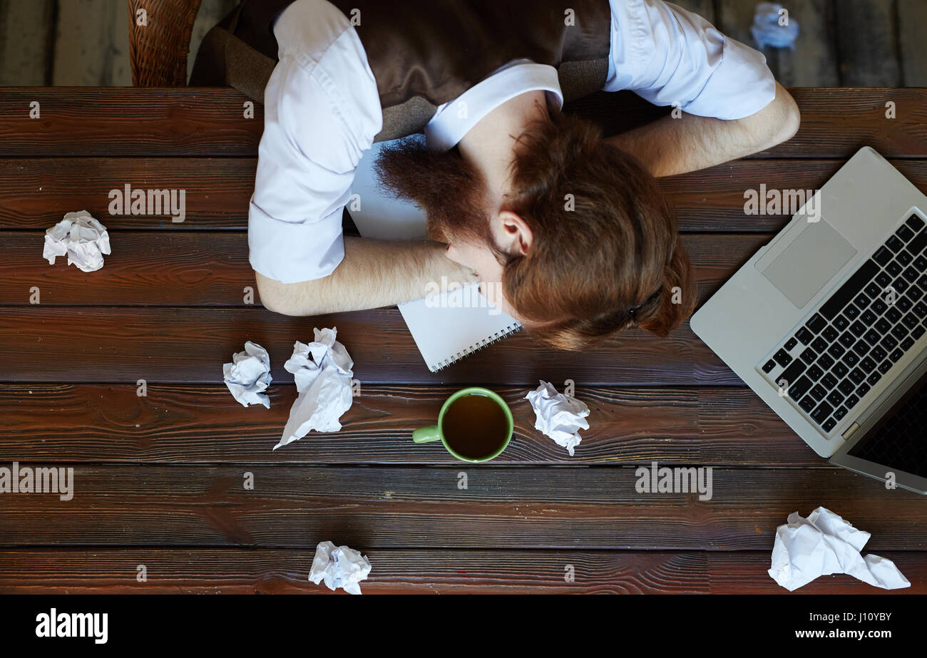 Tired man with his head on workplace napping after work Stock Photo - Alamy