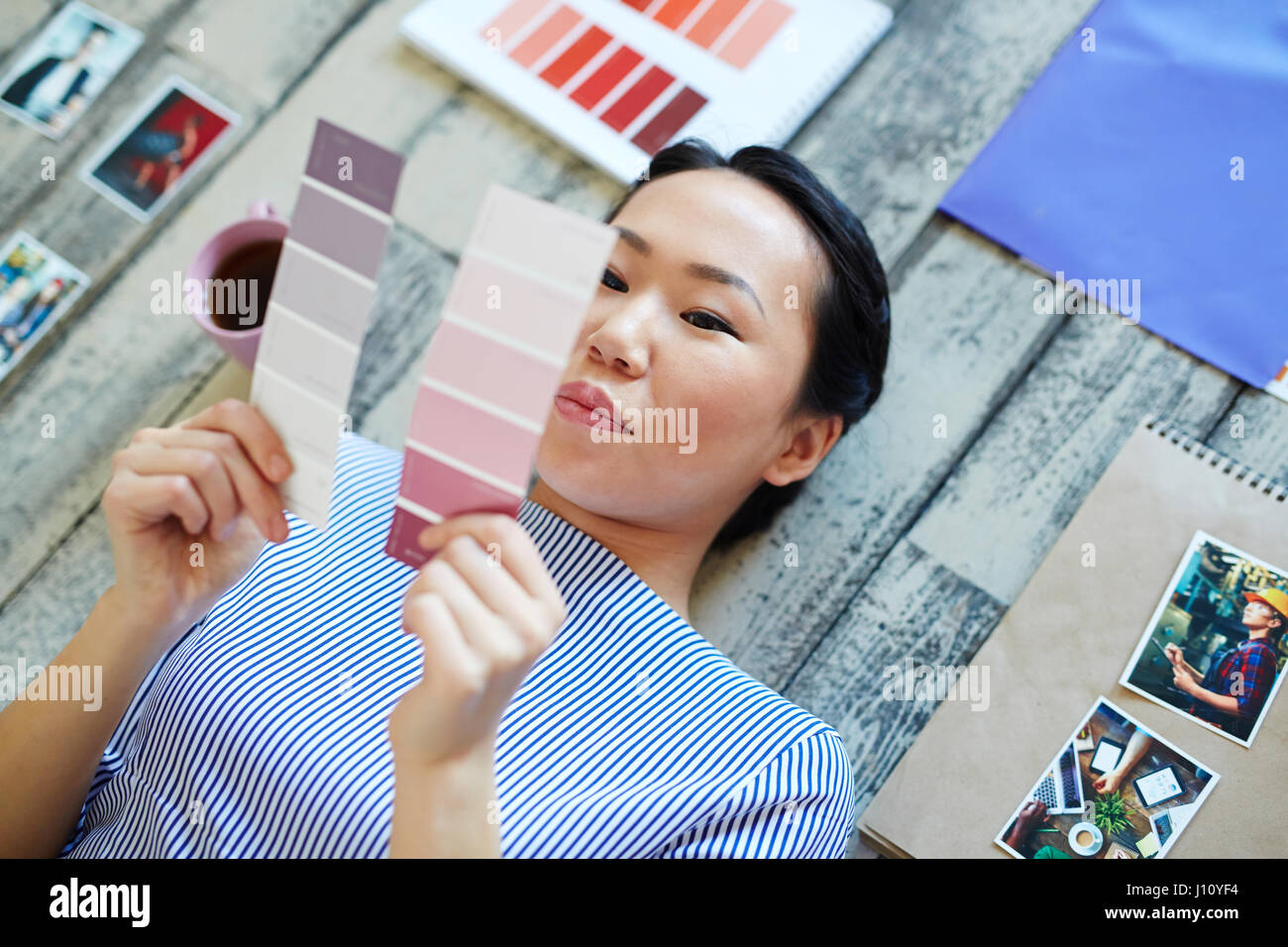 Girl looking at color swatches and choosing between them Stock Photo ...