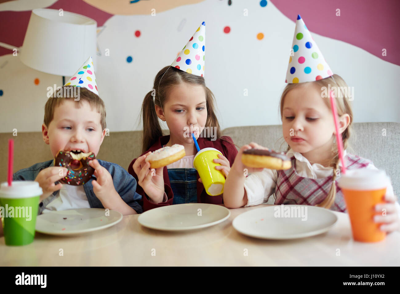 Group of hungry children eating donuts with soda Stock Photo - Alamy