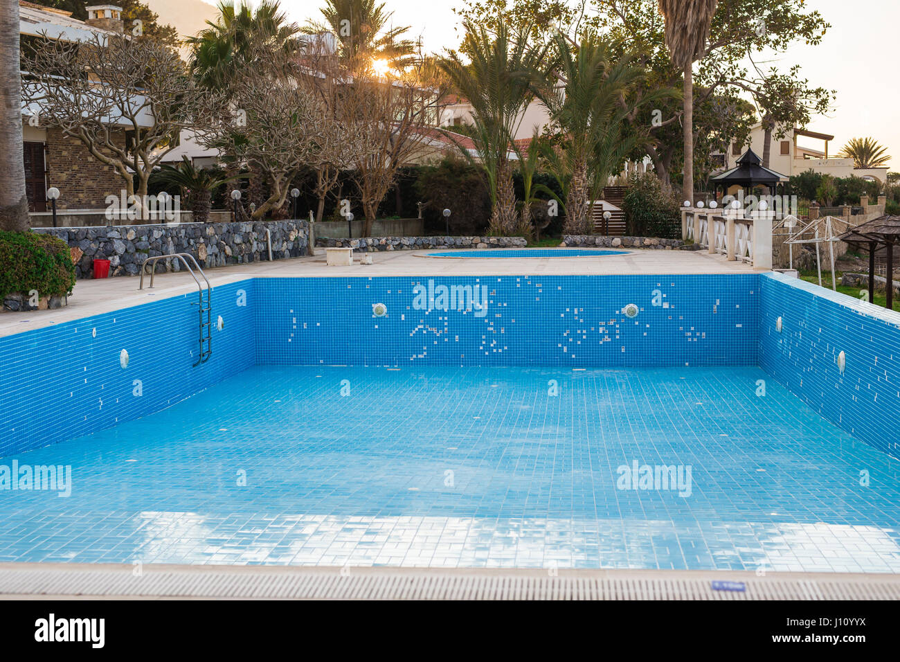 Empty swimming pool with metal ladder Stock Photo - Alamy