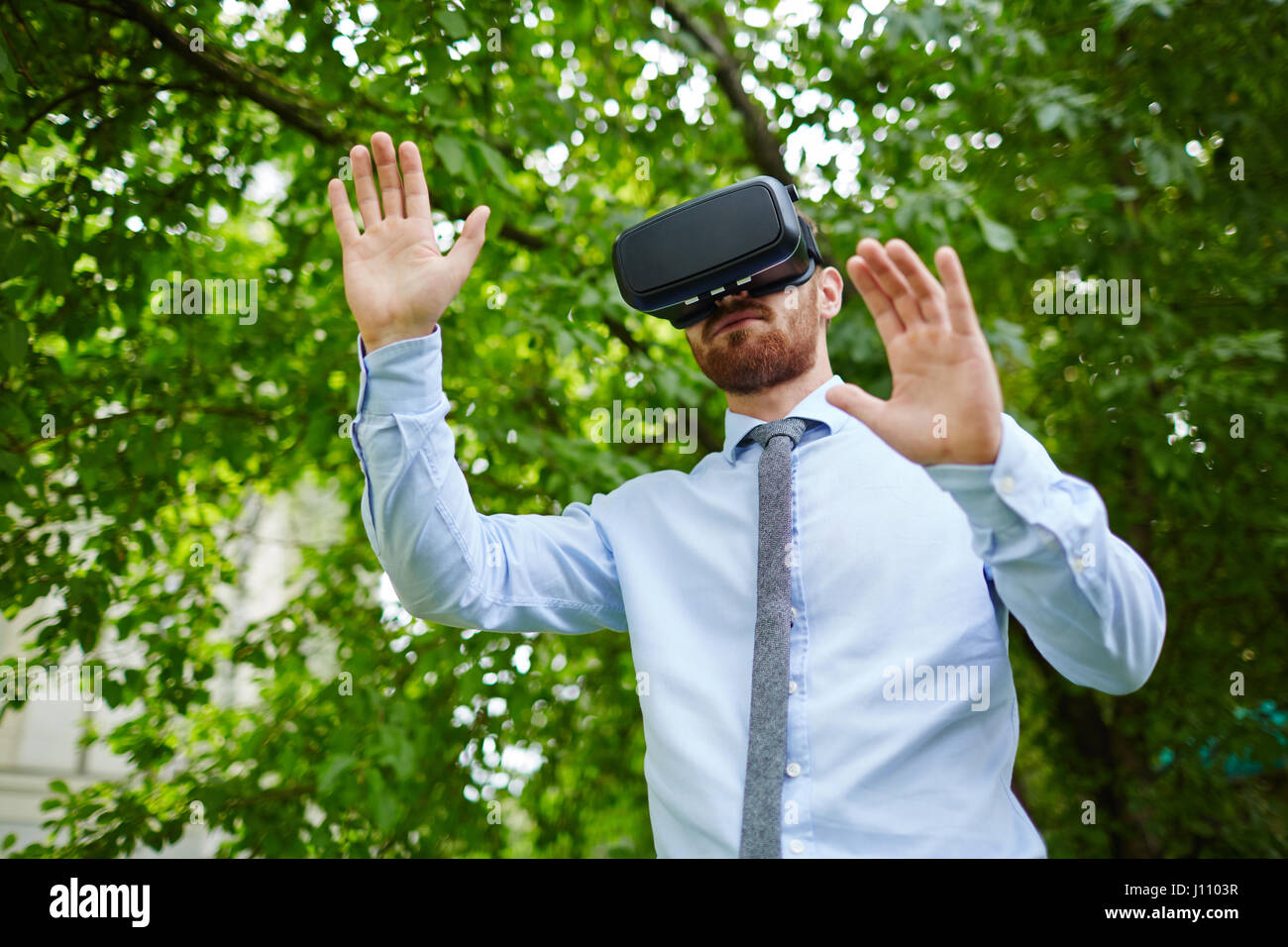 Portrait of man wearing VR headset experiencing nature walking in ...