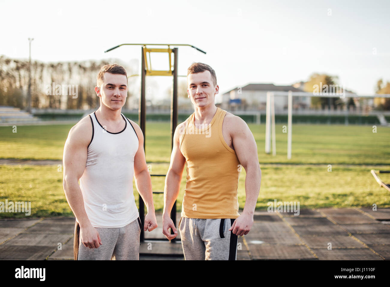 Two man stand at stadium with sunset background Stock Photo - Alamy