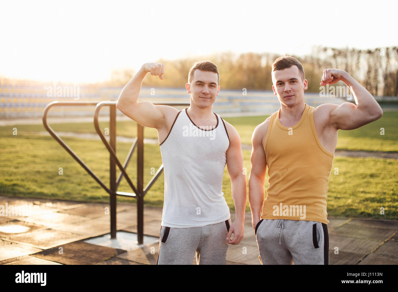 Two man stand at stadium with sunset background Stock Photo - Alamy
