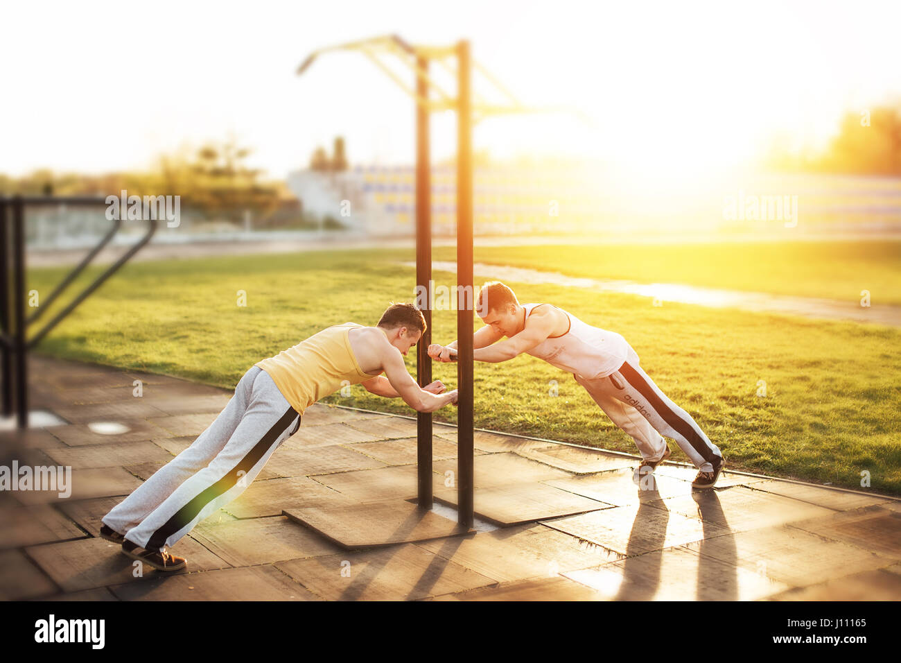 Two man stand at stadium with sunset background Stock Photo - Alamy