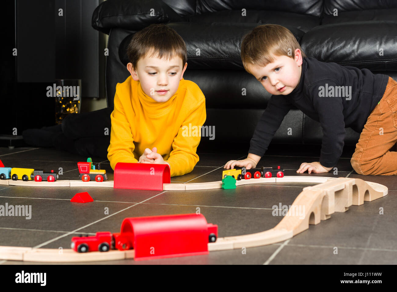 Children playing with wooden toy train. Brothers build wooden railroad ...