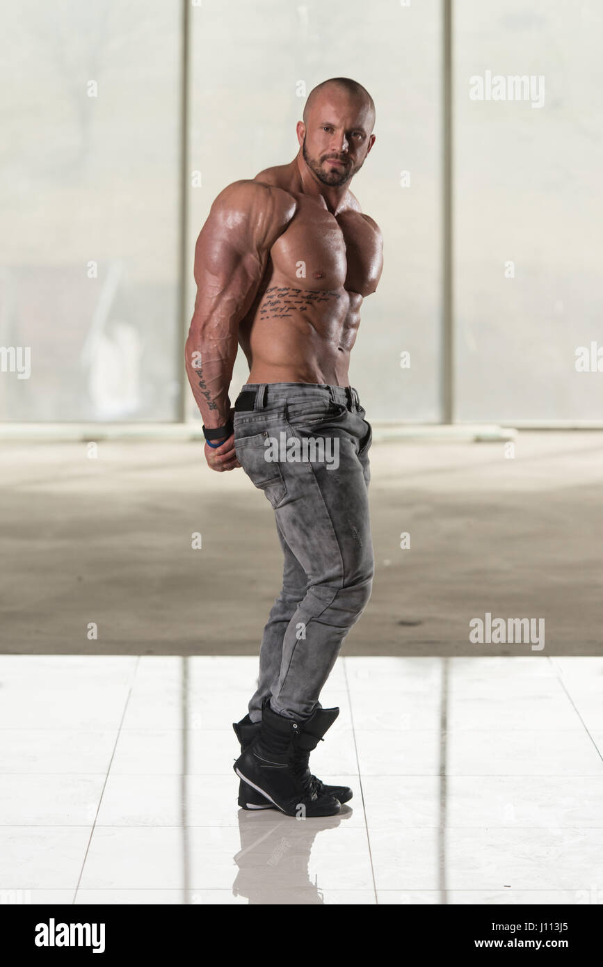 Handsome Young Man Standing Strong In Pants And Flexing Muscles ...