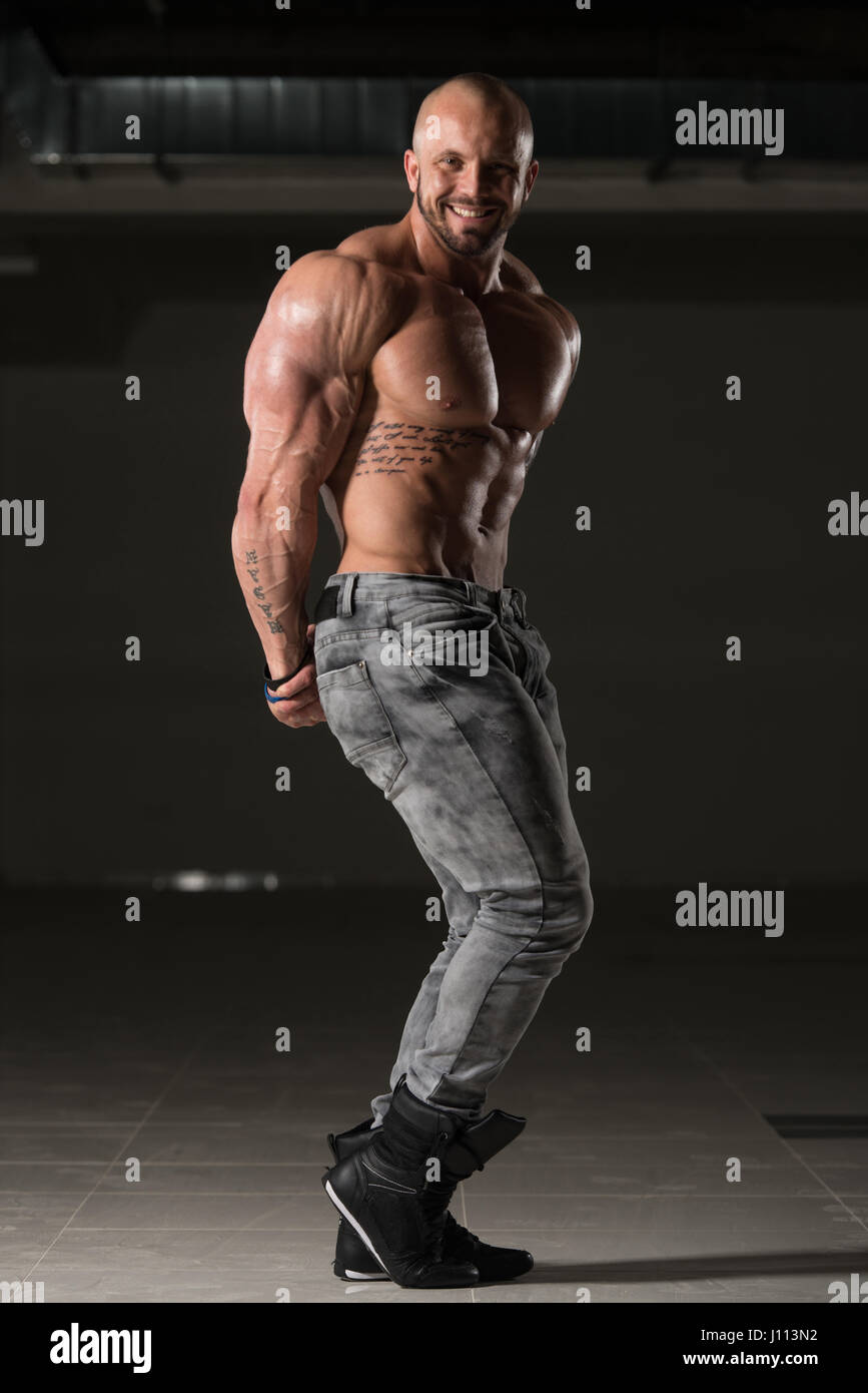 Handsome Young Man Standing Strong In Pants And Flexing Muscles ...